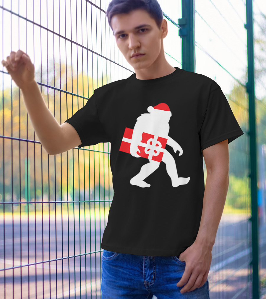 Nice Bigfoot Carrying Christmas Gift In Santa Hat T-Shirt