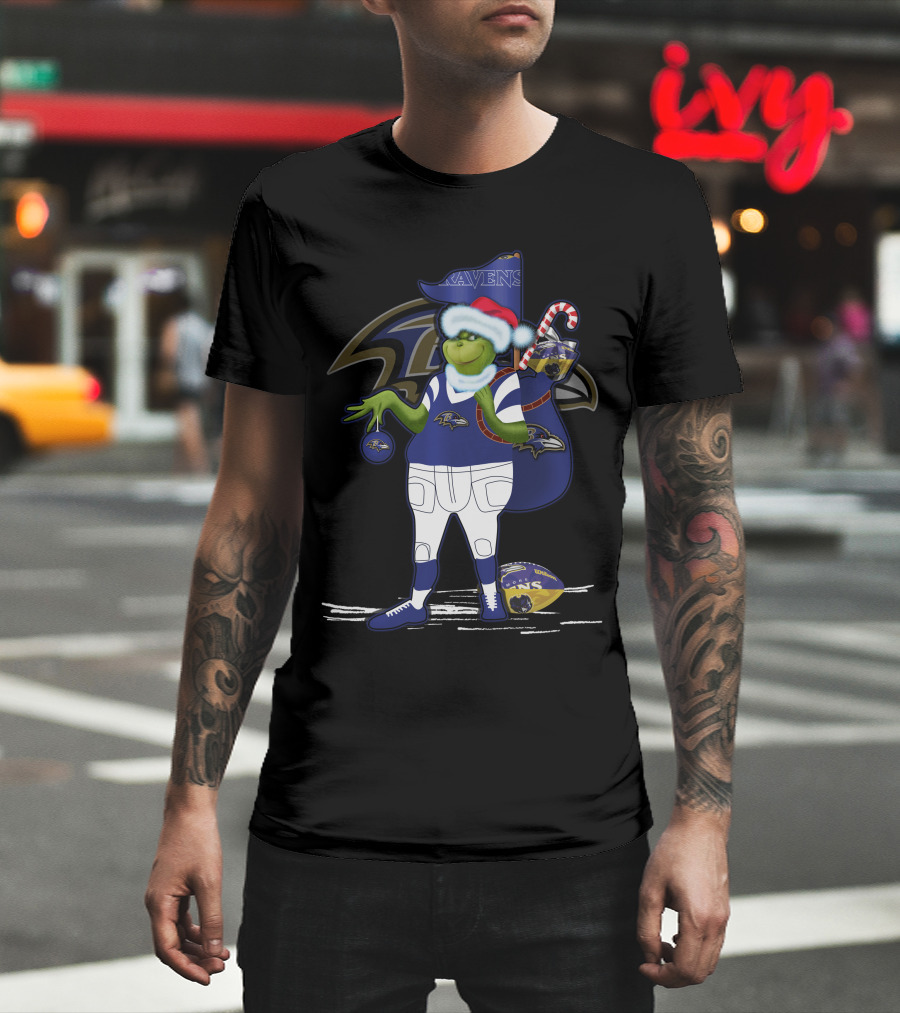 Grinch Santa Holding Candy Cane Bag And Baltimore Ravens Football In Ravens T-Shirt