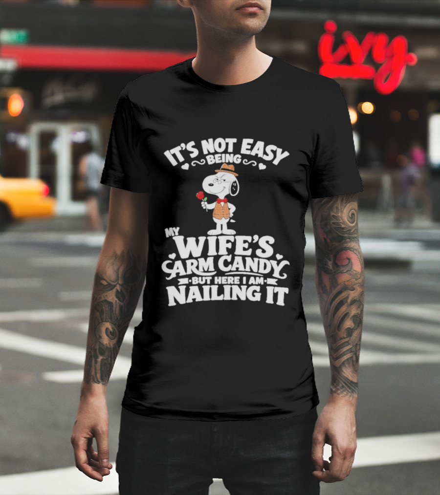 Snoopy It's Not Easy Being My Wife's Arm Candy But Here I Am Nailing It T-Shirt
