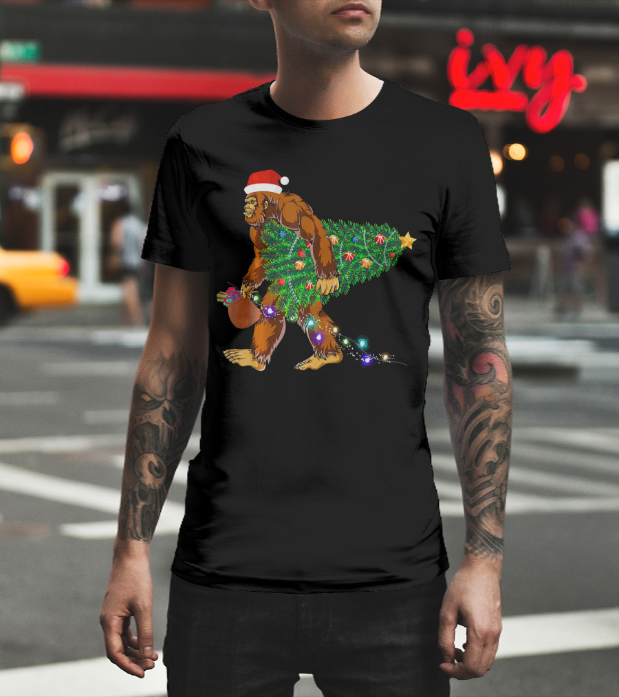 Santa Hat Bigfoot Holding Christmas Tree With Lights And Gifts T-Shirt