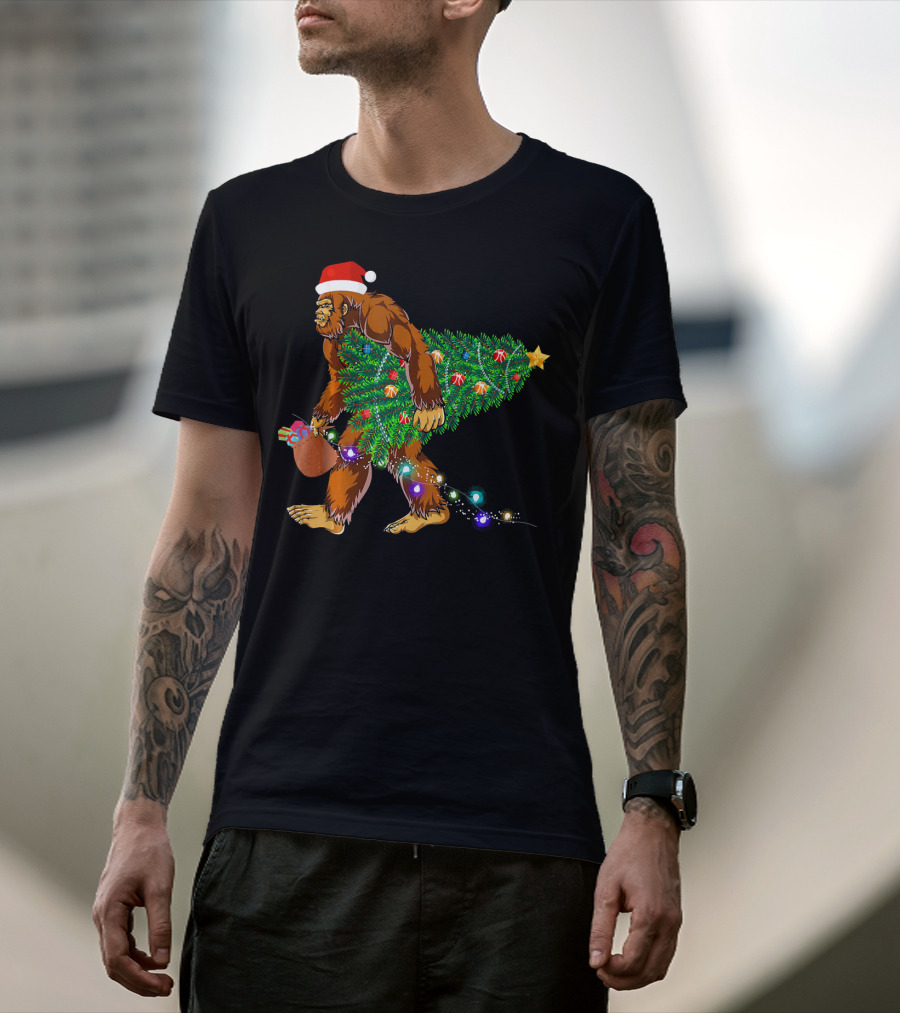 Santa Hat Bigfoot Holding Christmas Tree With Lights And Gifts T-Shirt