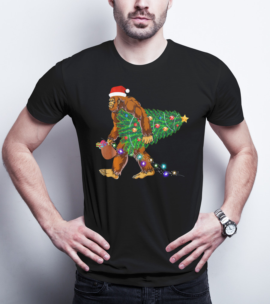 Santa Hat Bigfoot Holding Christmas Tree With Lights And Gifts T-Shirt